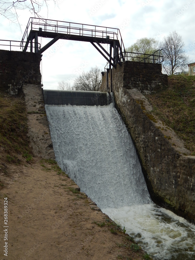Old dam with a waterfall, rusty metal and concrete structures Stock ...
