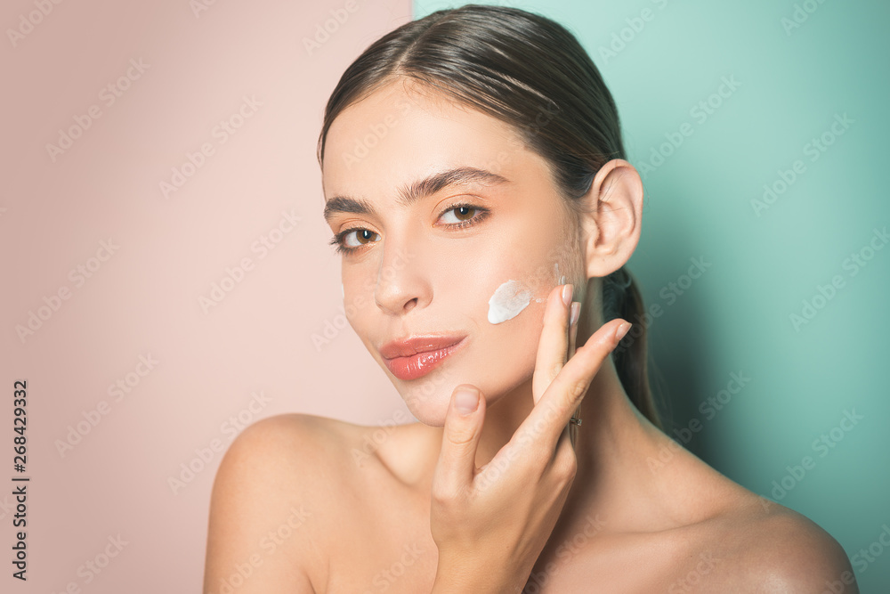 Beautiful woman spreading cream on her face. Skin cream concept. Facial ...