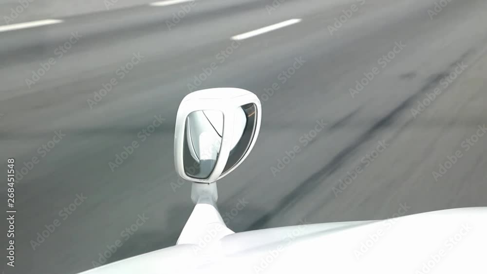 a fender mirror on the bonnet of white car while driving on a highway ...