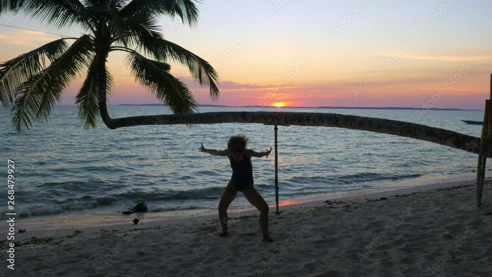 Woman performing modern dance on tropical beach at sunset palm tree Wab ...