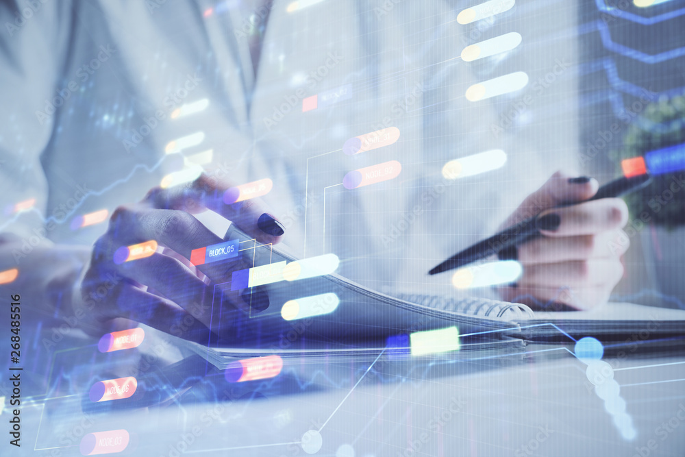 Multi exposure of hands making notes with digital coding icons ...