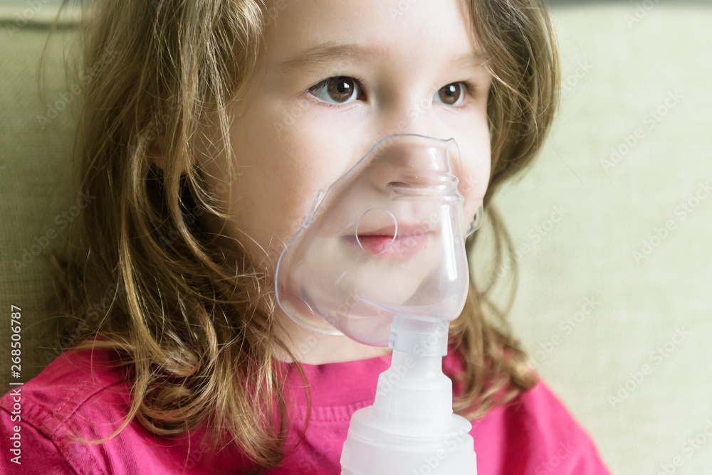 Little girl with inhaler mask close-up. Sick kid breathes through a ...
