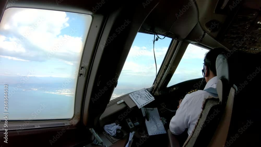 Airline captain controlling the airplane flying over the sea to land on ...