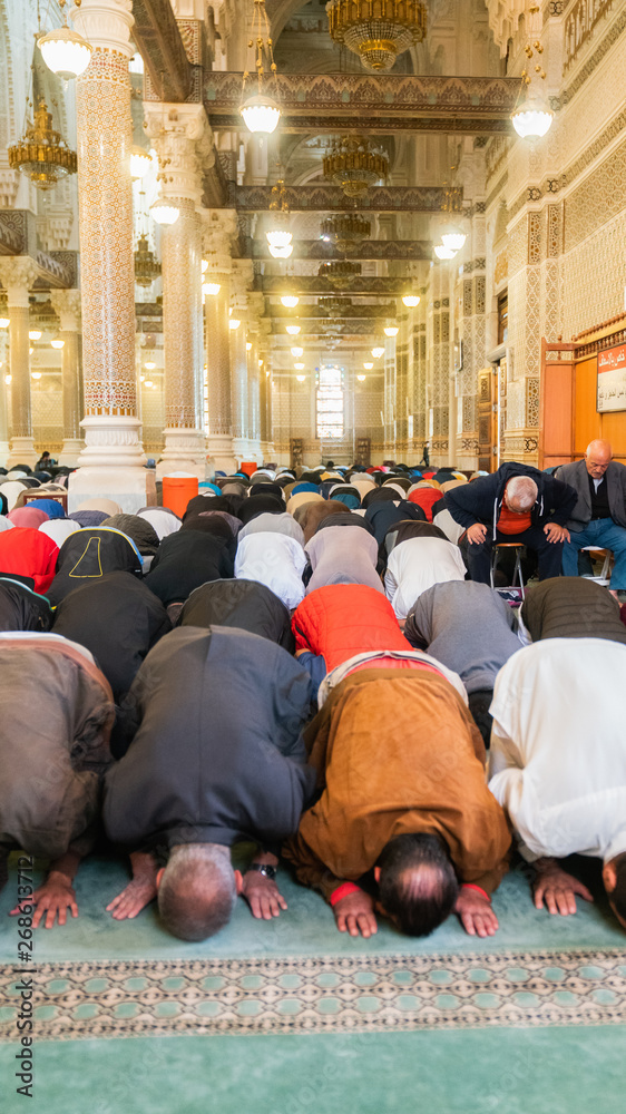 Muslim men bowing, kneeling and praying inside of a big mosque in ...