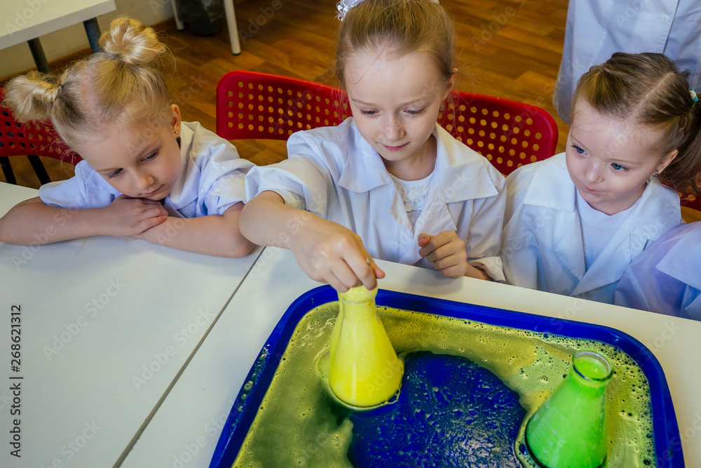 group of school girl kids with teacher in school laboratory making ...