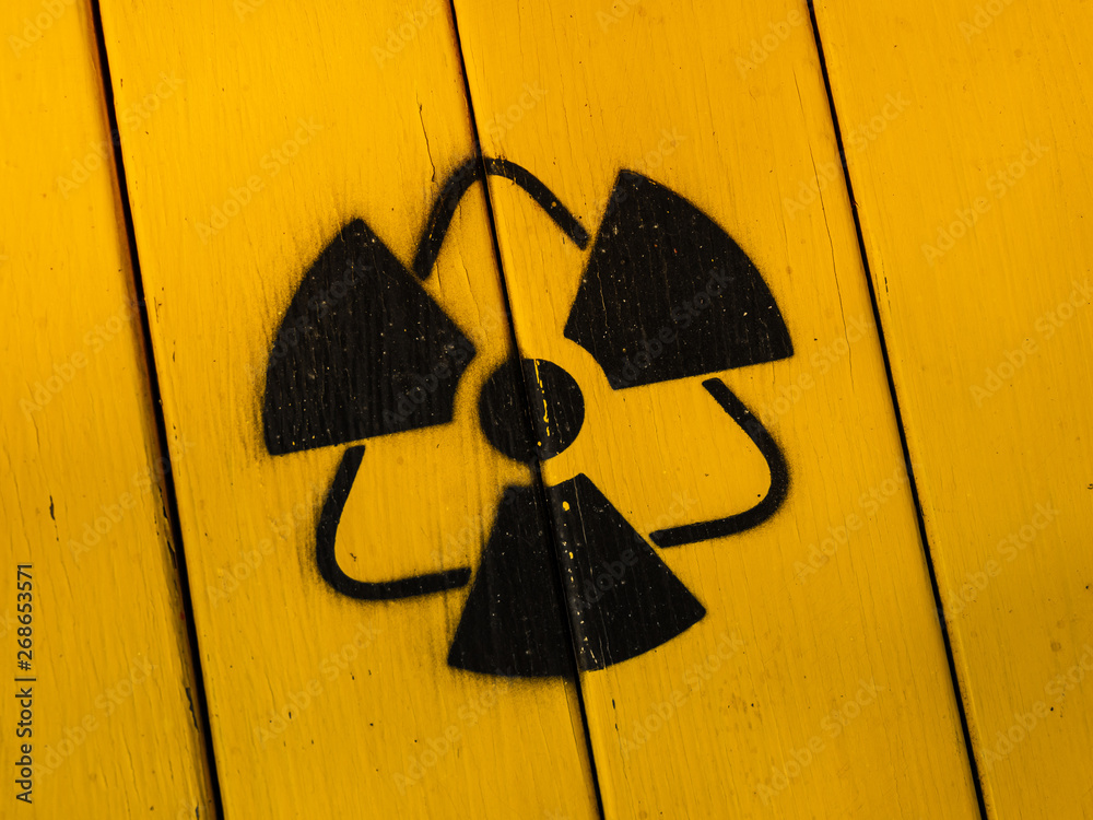Radioactivity sign, close-up. Sign of radiation on a yellow wooden ...