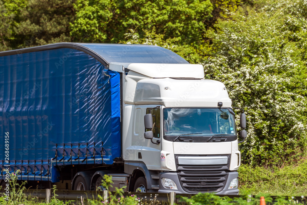 blue curtain side lorry truck on uk motorway in fast motion Stock Photo ...