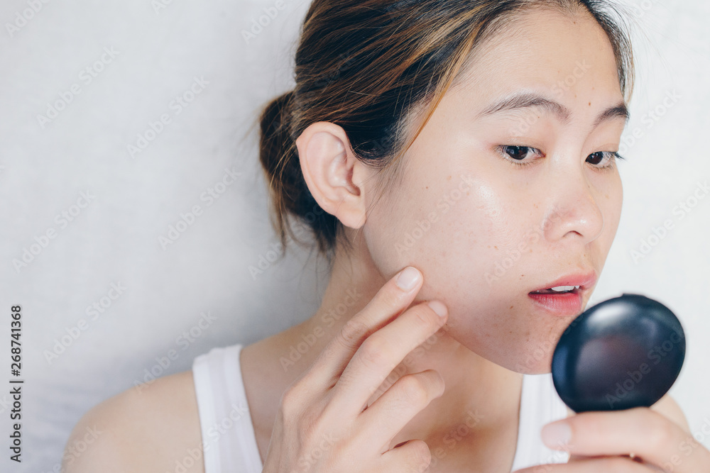 Portrait of Asian woman worry about her face when she saw the problem ...