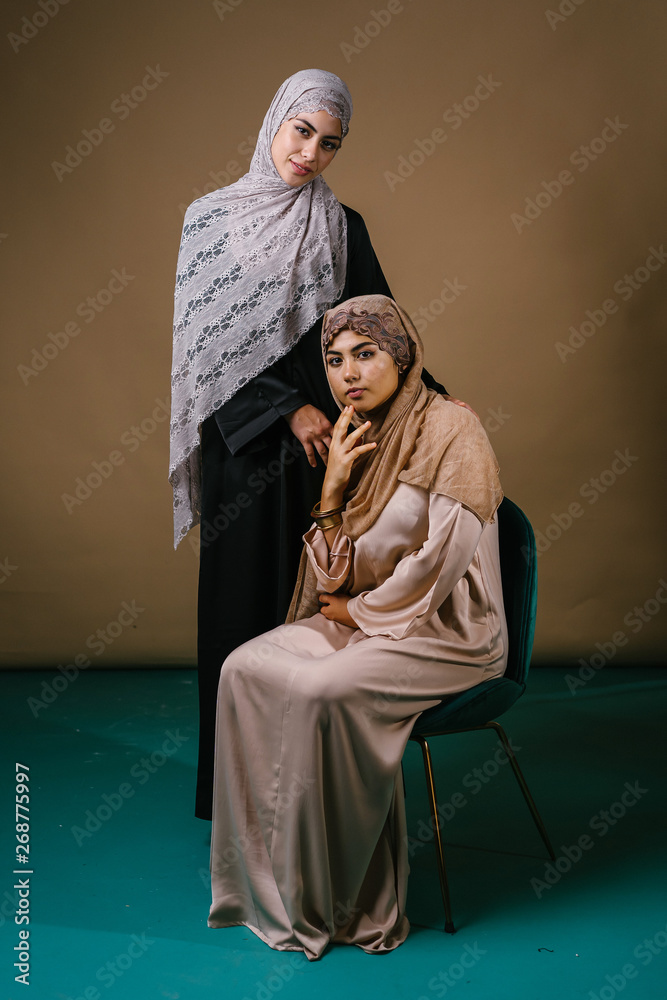 Two Indonesian Asian Muslim sisters in traditional dresses and hijab ...