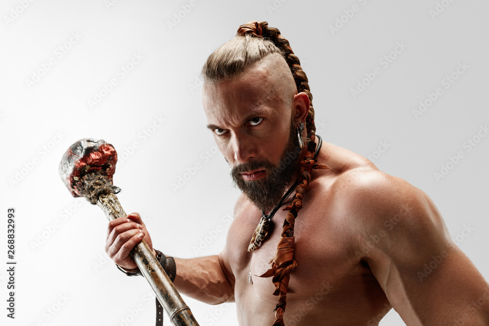 Serious long hair and muscular male model in leather viking's costume ...