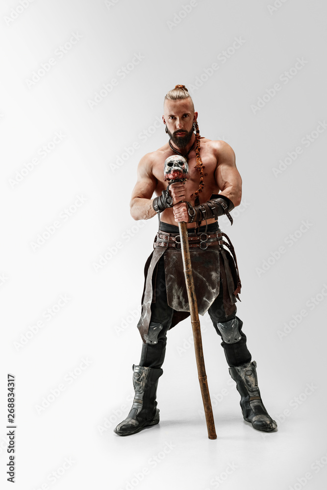 Serious long hair and muscular male model in leather viking's costume ...