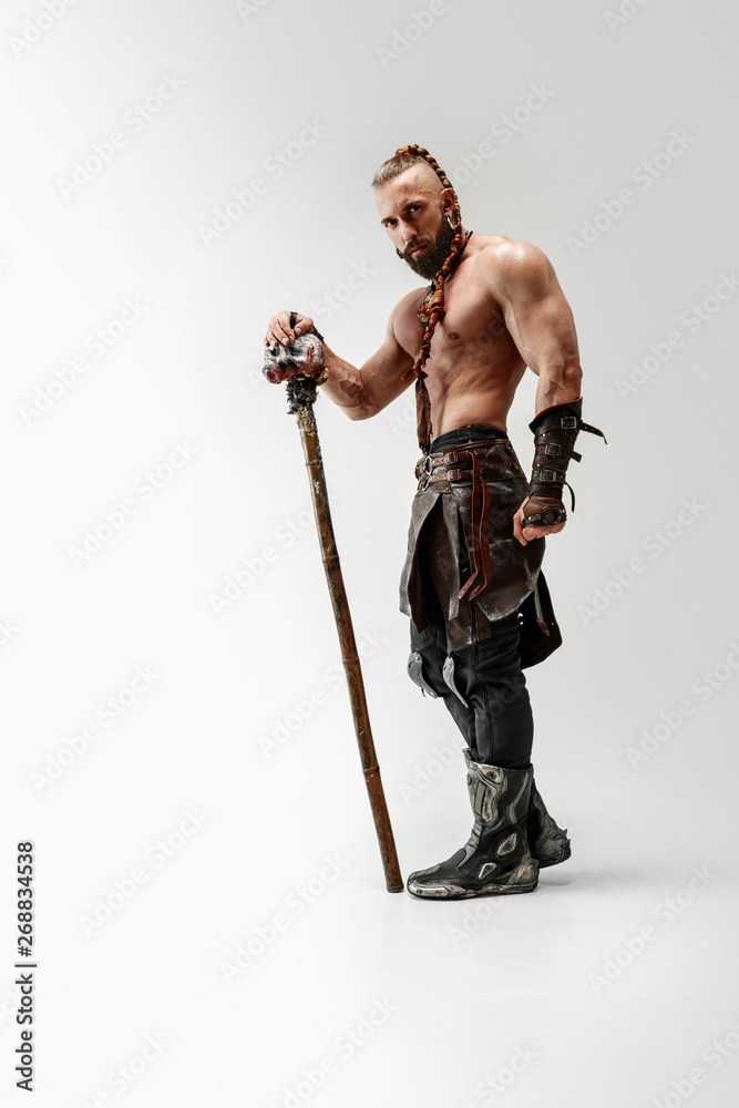 Serious long hair and muscular male model in leather viking's costume ...
