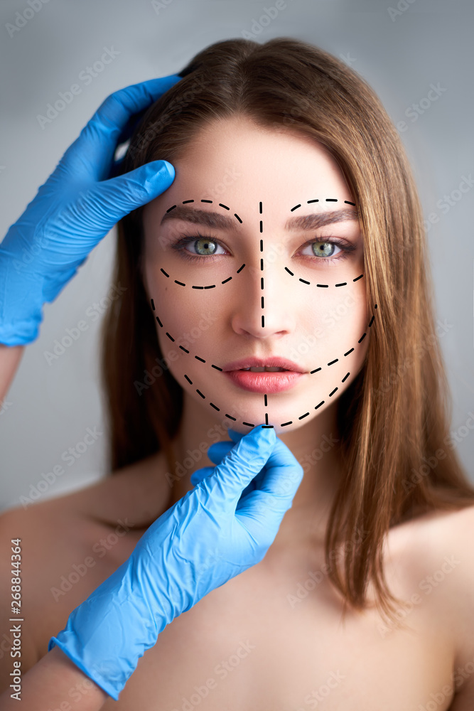 Beautiful young woman with perforation lines on her face before plastic ...