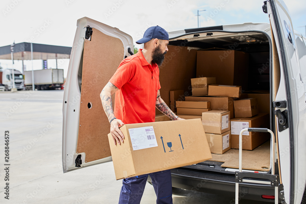 Delivery man in uniform loading the truck. Stock Photo | Adobe Stock