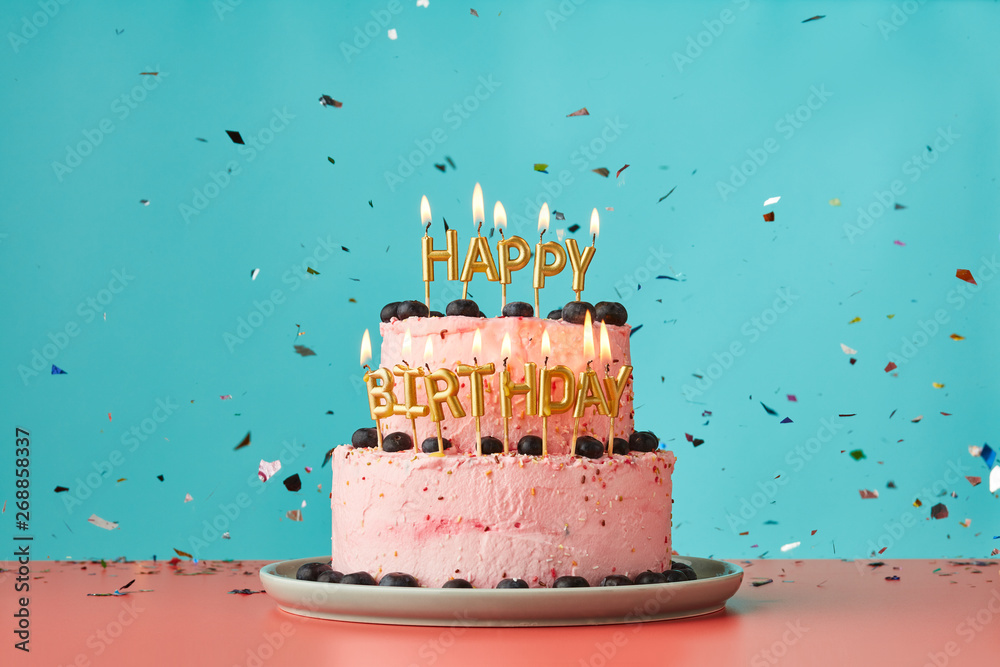 Happy birthday cake with candles and confetti. Stock Photo | Adobe Stock