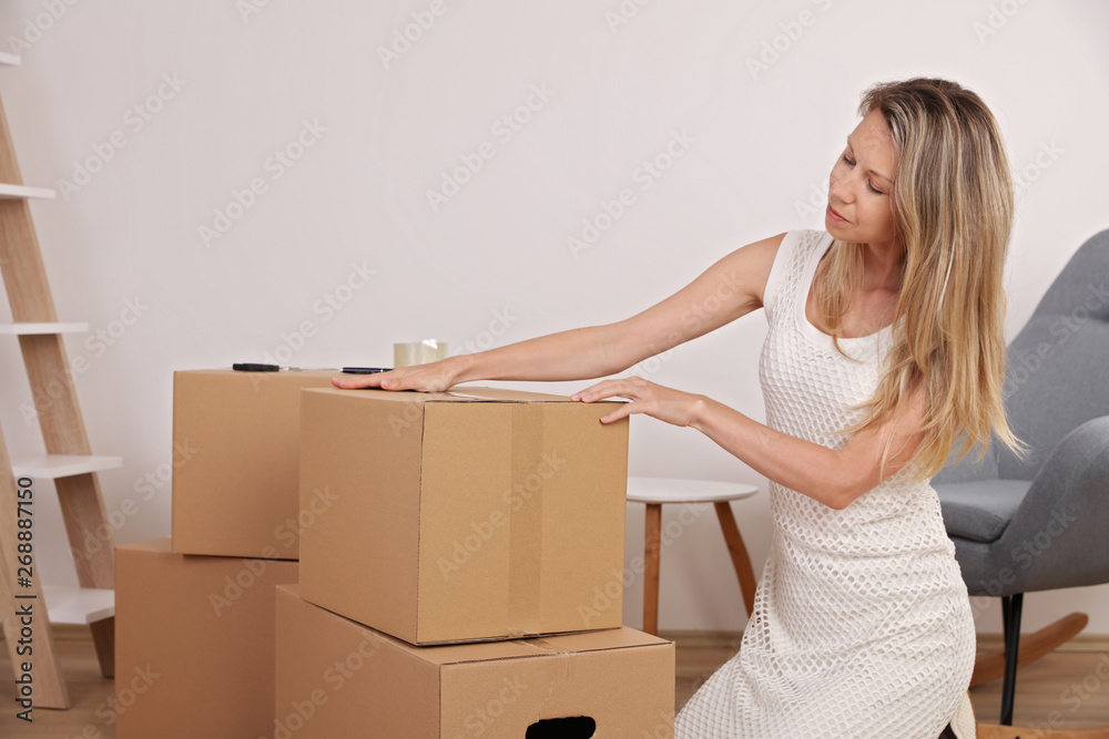 Moving in and out. Woman packing and labeling moving box at home Stock ...