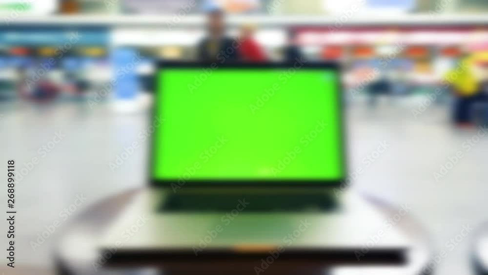 Blurry footage working on laptop with green screen on table in the ...