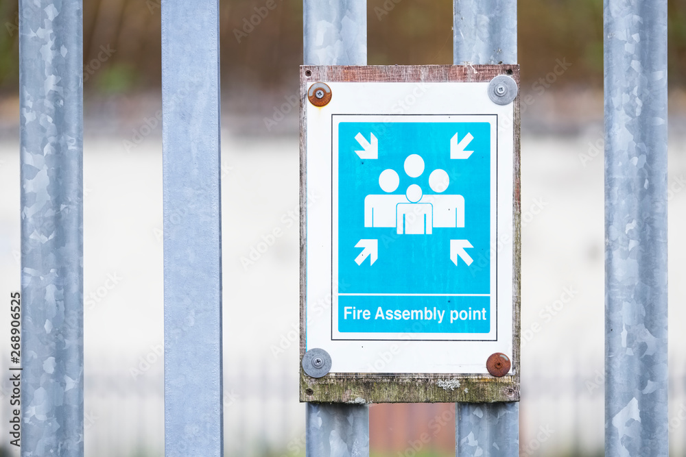 Fire assembly point blue sign on fence Stock Photo | Adobe Stock