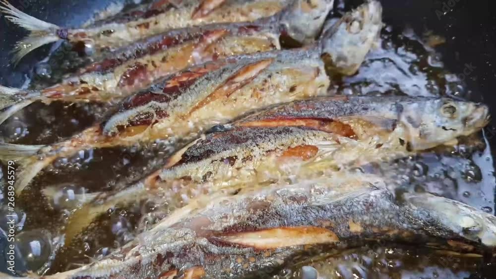 Frying fresh small fish in a frying pan,a common method in the ...