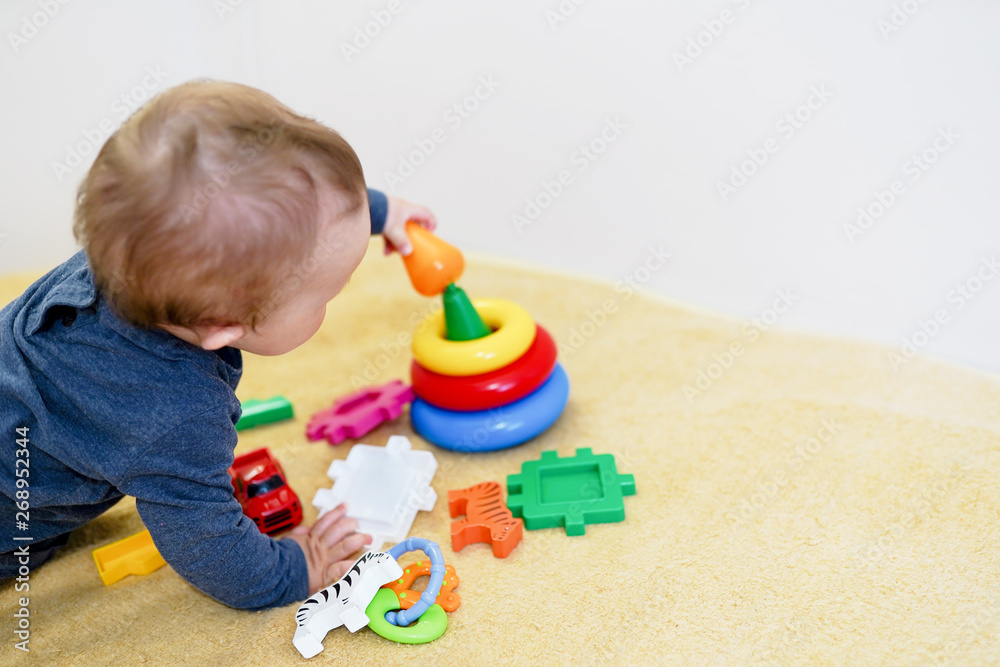 Baby smilling and playing with colorful toys at home. child background ...
