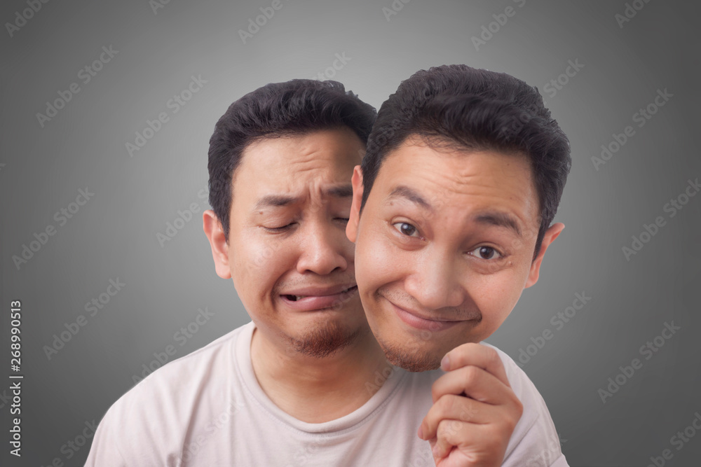 Sad Man with Happy Face Mask Stock Photo | Adobe Stock