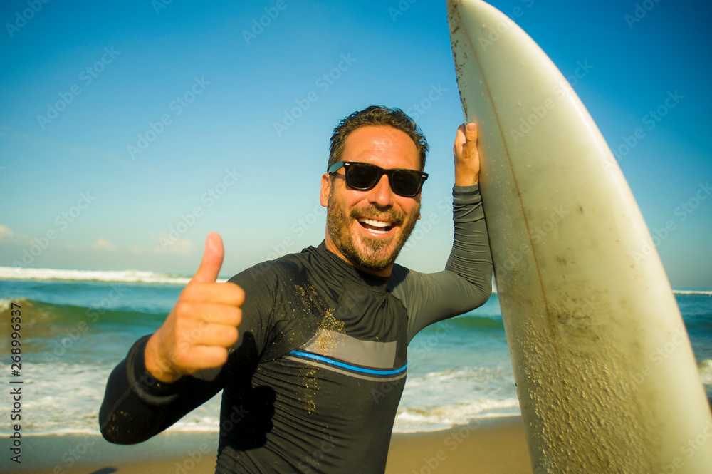 lifestyle portrait of attractive and happy surfer man 3os to 40s in ...