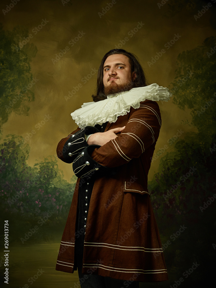 Young man as a medieval knight on dark studio background. Portrait in ...