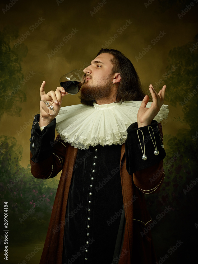 Young man as a medieval knight on dark studio background. Portrait in ...