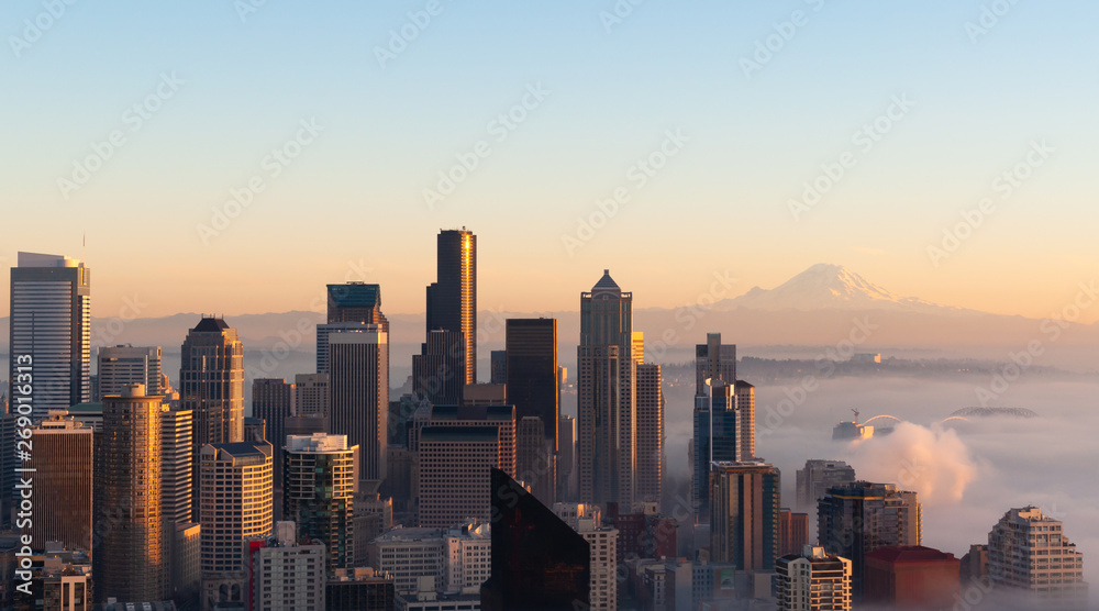 Seattle skyline with golden sunset light partially immersed in the fog ...