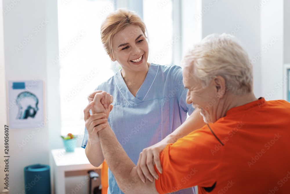 Joyful positive nurse smiling to her patient Stock Photo | Adobe Stock