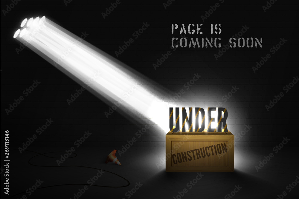 Banner Under construction on wood box in spotlights on black background ...