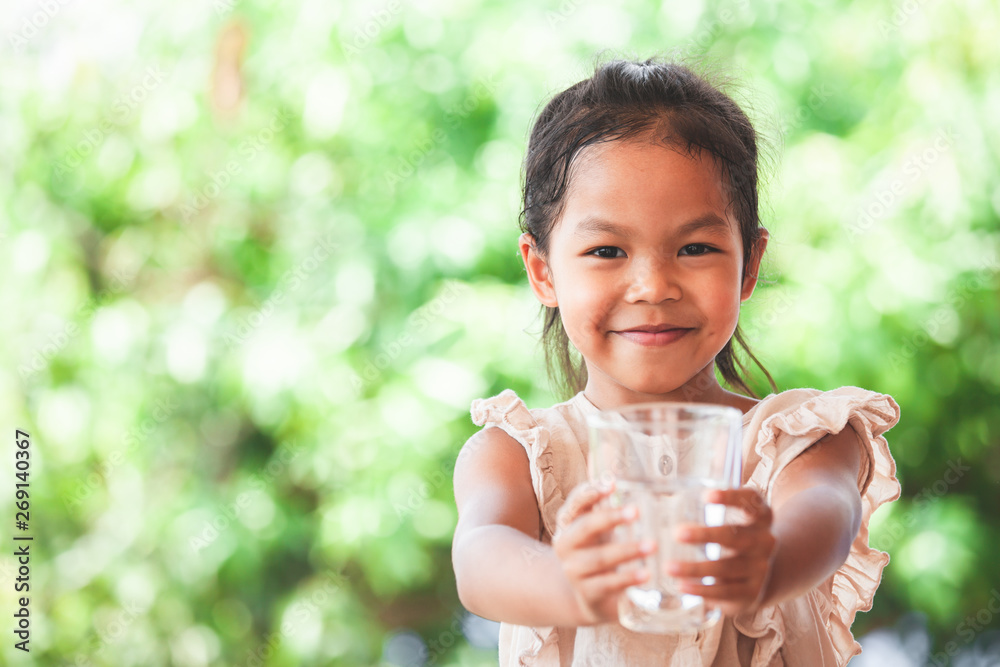 Cute asian child girl like to drink water and holding glass of fresh ...