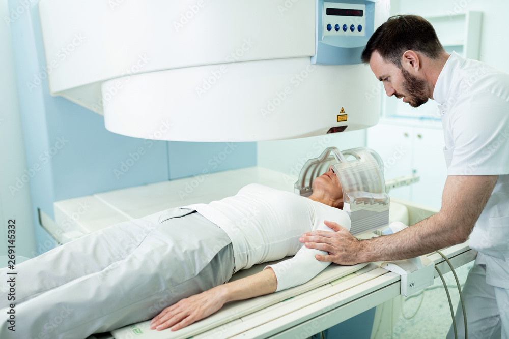 Female patient being comforted by doctor during brain MRI scan ...