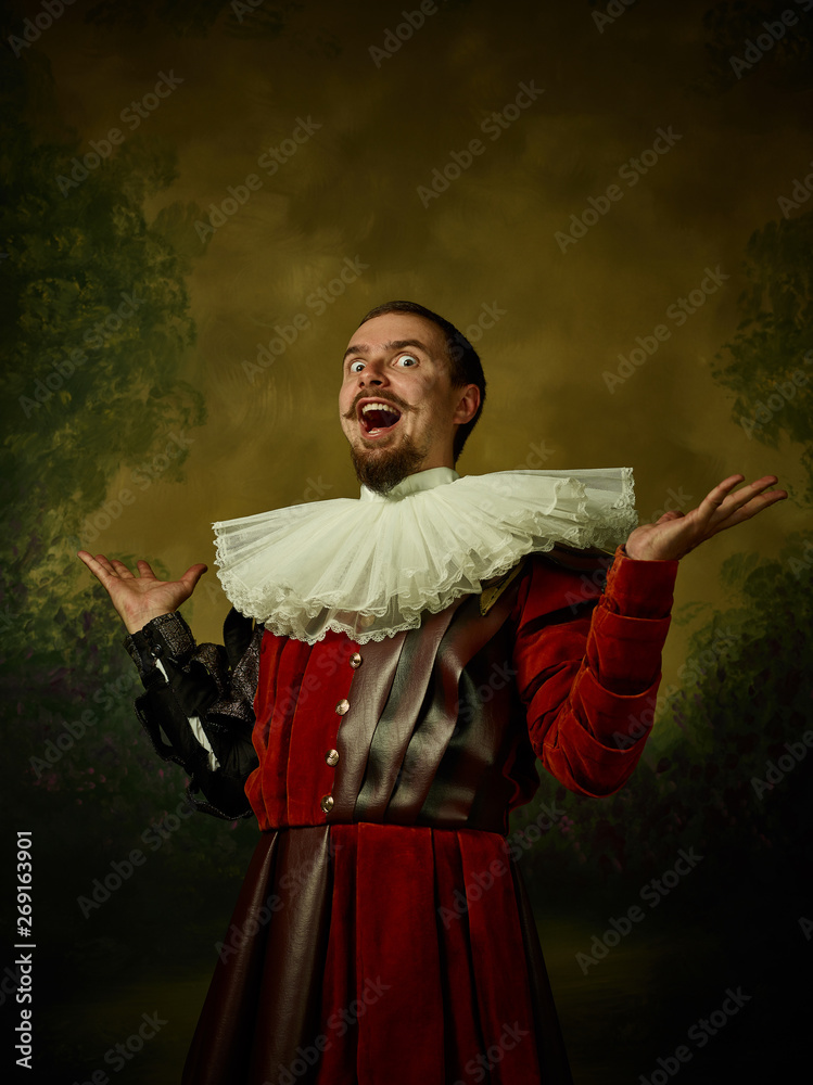 Young man as a medieval knight on dark studio background. Portrait in ...