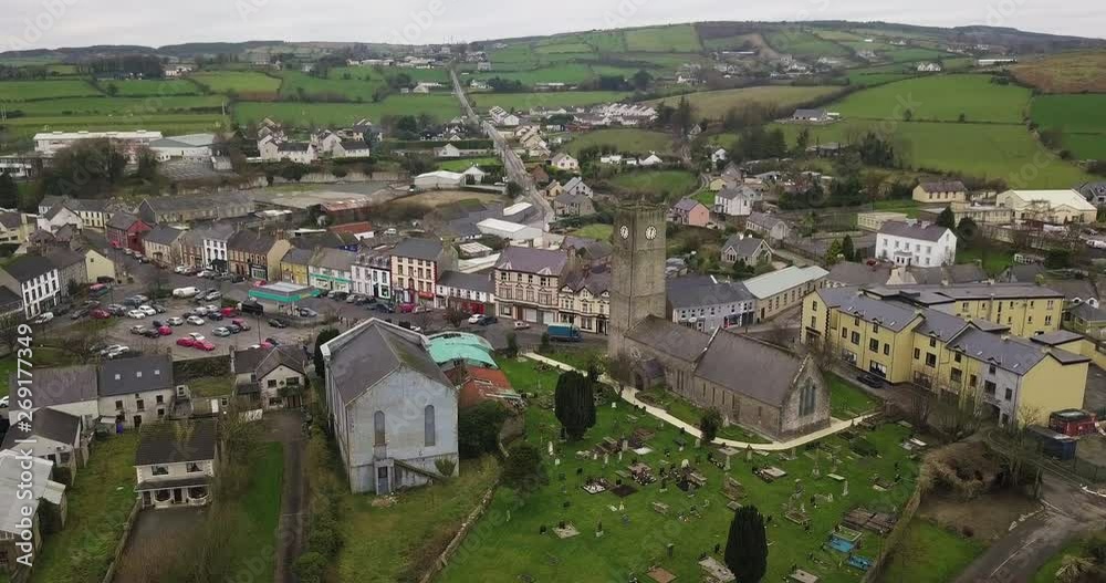Extreme wide aerial rise over an Irish town with a view of the church ...