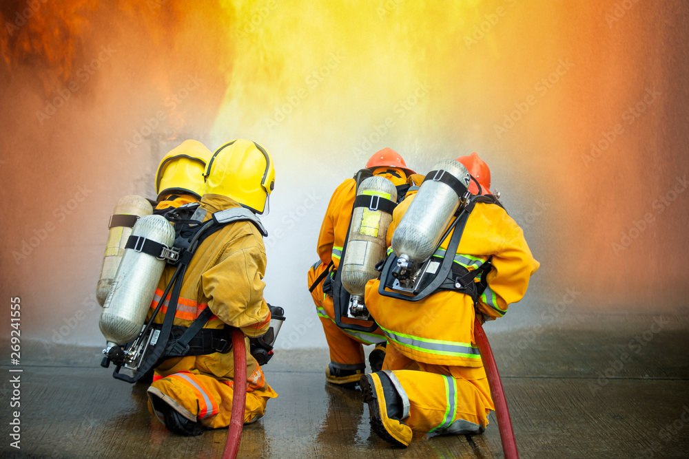 Firefighters spraying high pressure water to fire with copy space, Big ...