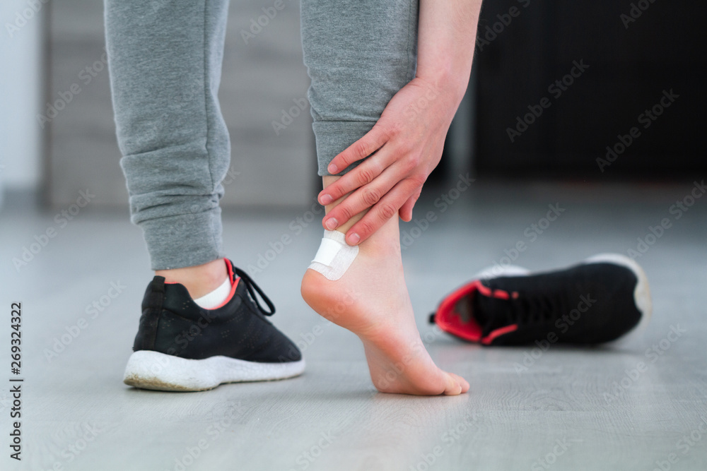Woman's heel with white medical adhesive plaster from calluses during ...
