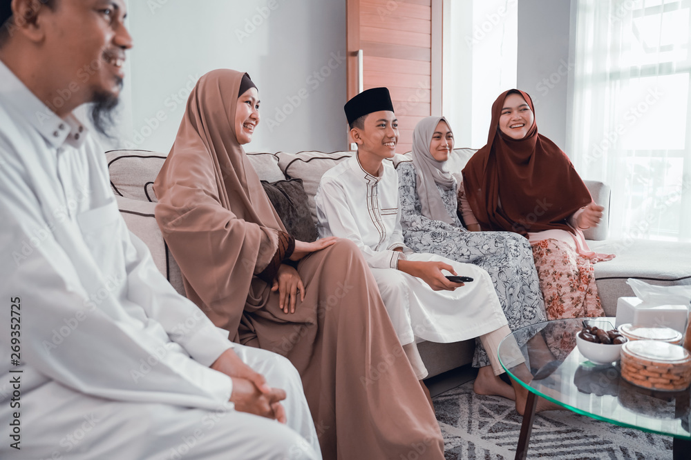happy muslim family watching tv together at home livingroom Stock Photo ...