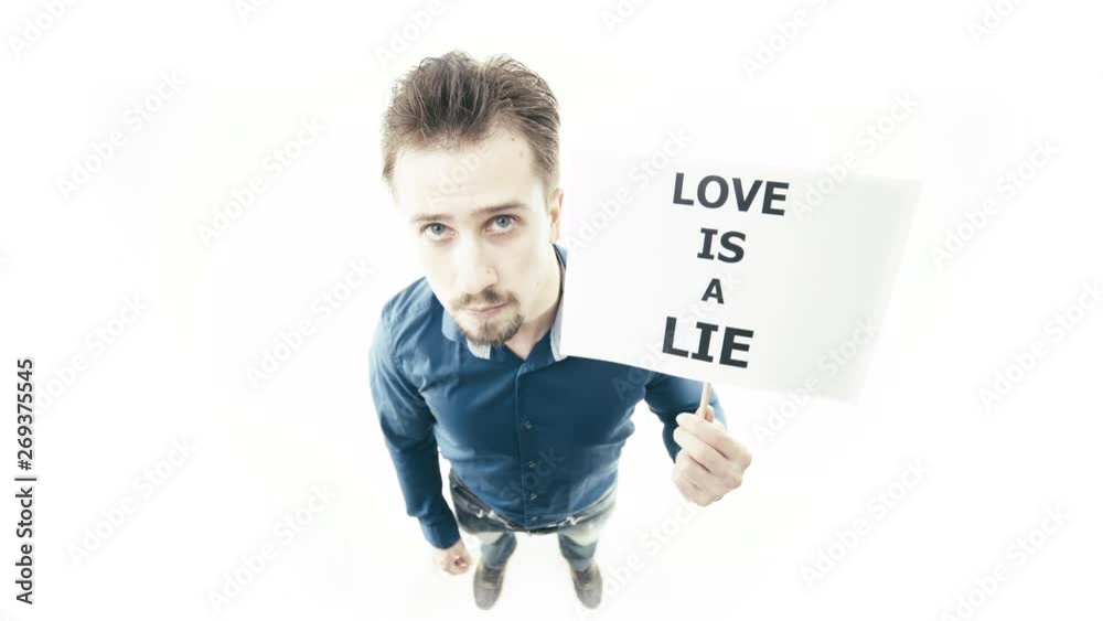 Man holding sign Love Is A Lie 4K. Extreme wide shot top view of person ...