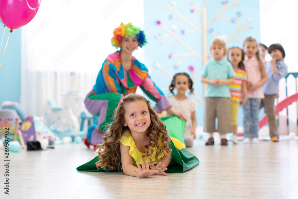 Happy children playing in childrens playroom for birthday party or ...