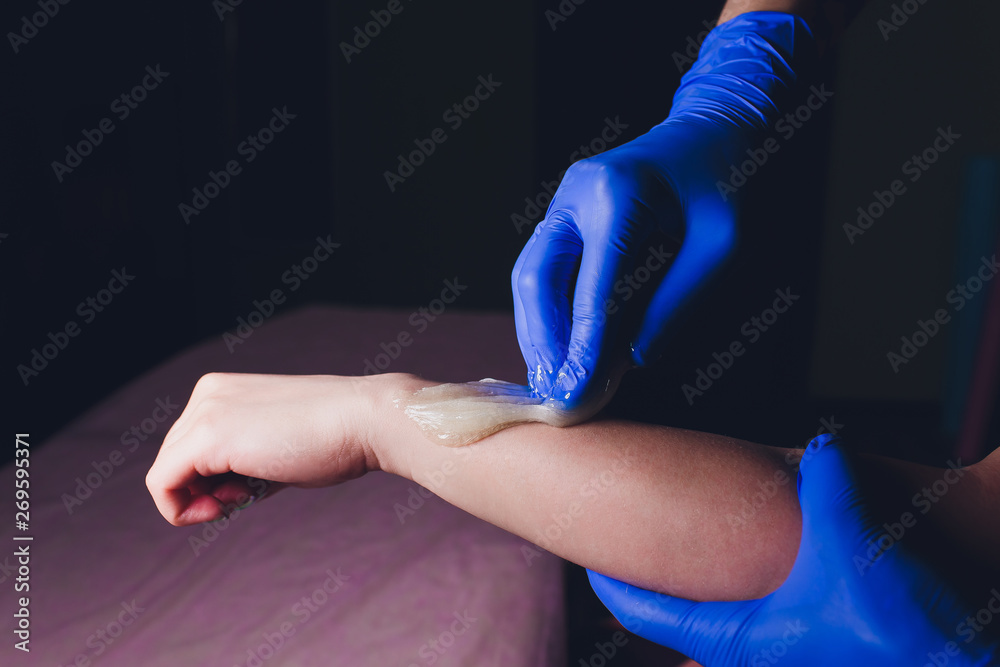 Sugaring. Beauty Concept. Young beautiful girl with dark hair gets the ...