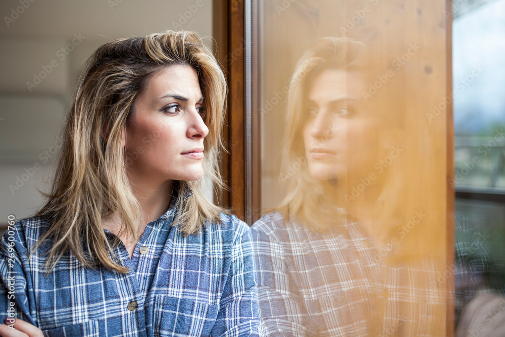 Beautiful and young woman looking out the window of her house Stock ...