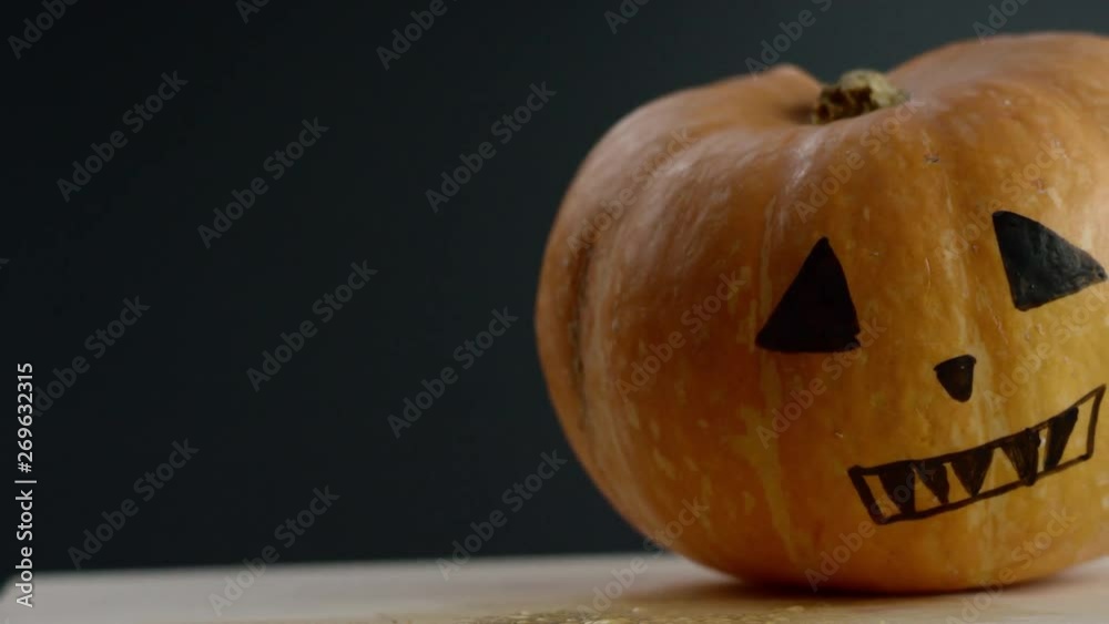 painted pumpkin, camera moves from left to the right, light black ...