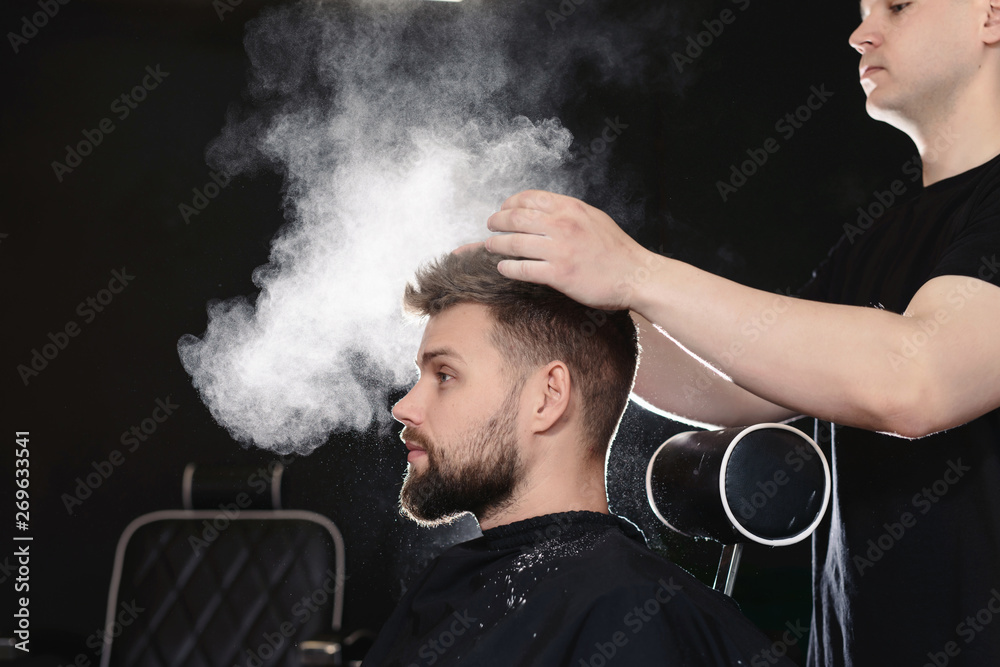 Professional hairdresser barber using talcum powder for his client hair ...