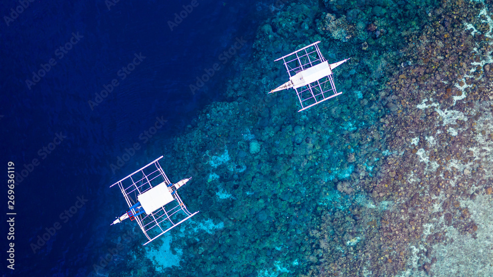 Aerial view of Filipino boats floating on top of clear blue waters ...