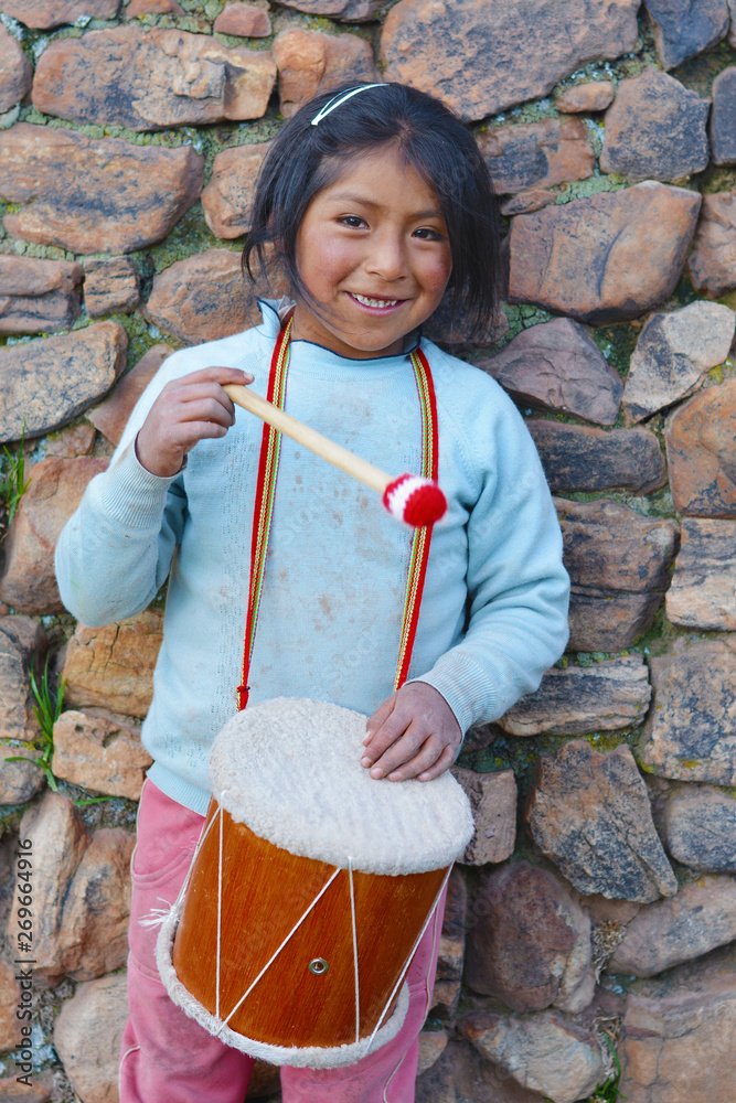 Little native american girl playing traditional sikuri drum. Stock ...