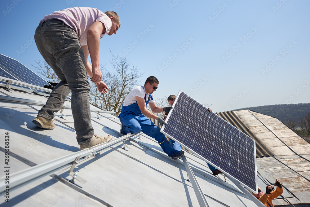 Male engineers installing solar photovoltaic panel system. Electricians ...