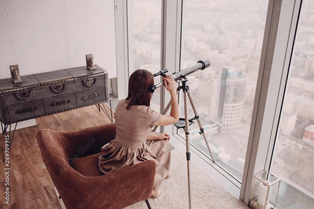 Woman looks telescope through window of skyscraper Stock Photo | Adobe ...