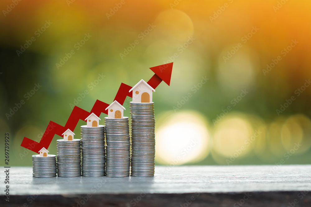 Stack gold coin and a red arrow graph with growing value and wooden ...