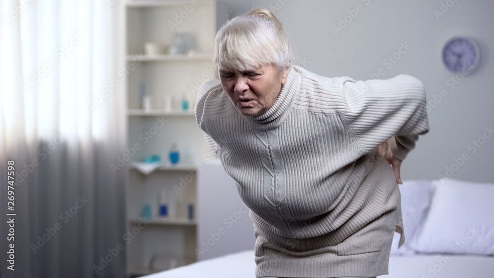 Foto de Elderly woman standing up from bed and suddenly feeling lower ...